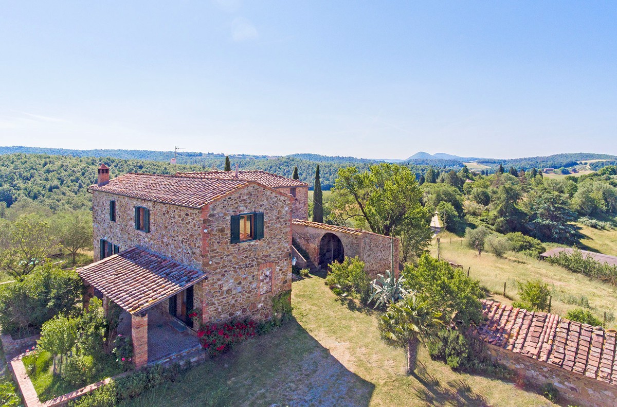 Rustic farmhouse in typical Tuscan hilly landscape